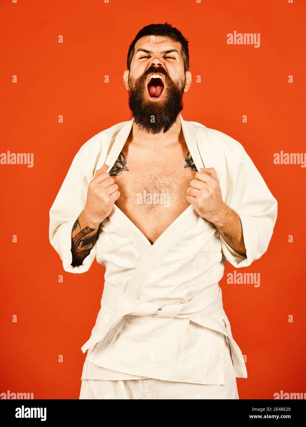 Man with beard in white kimono on red background. Japanese martial arts ...