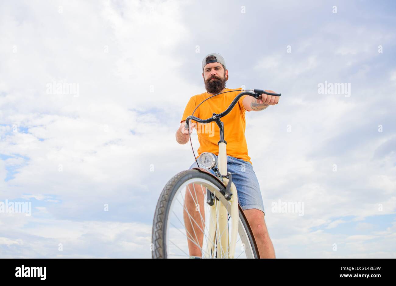 Man bearded hipster rides bicycle bottom view sky background. Overcome ...