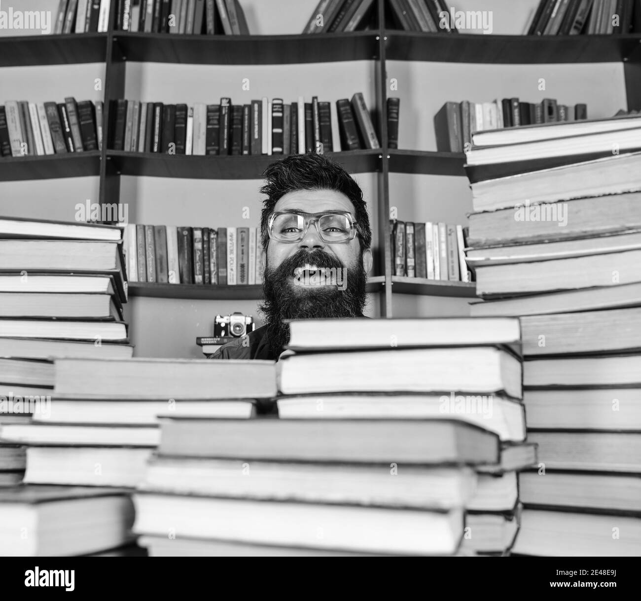 Teacher or student with beard wears eyeglasses, sits at table with ...