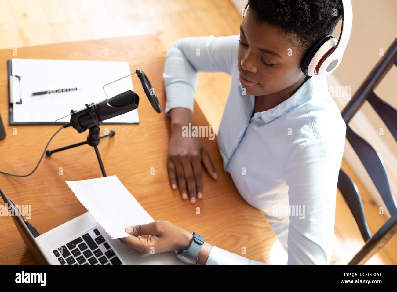 African american woman wearing headphones using microphone and laptop ...