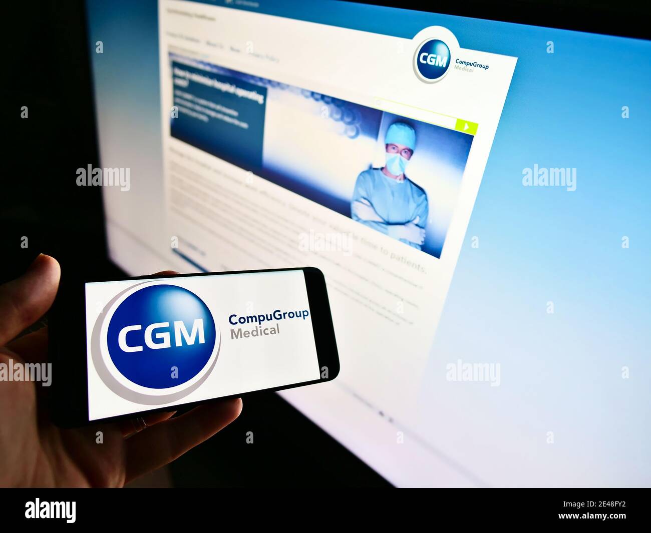 Person holding smartphone with logo of German software developer ...