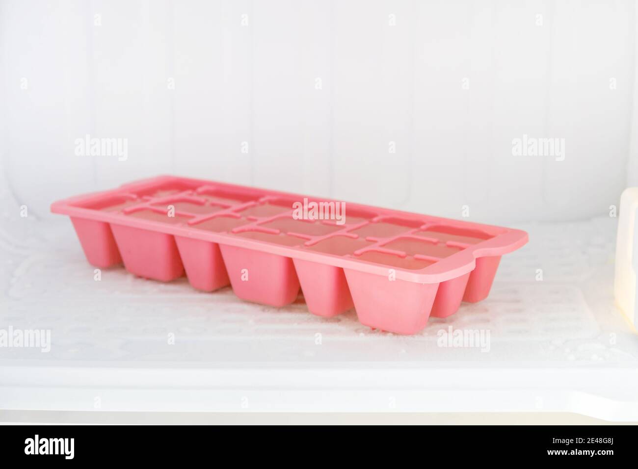 Colorful plastic ice tray in the freezer compartment of the ...