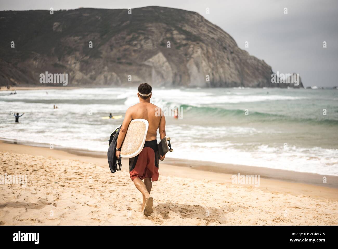surfer walking along the beach Stock Photo - Alamy