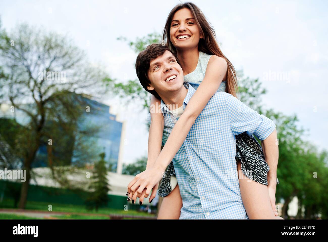 Young happy couple embracing and having fun in the summer in the city ...