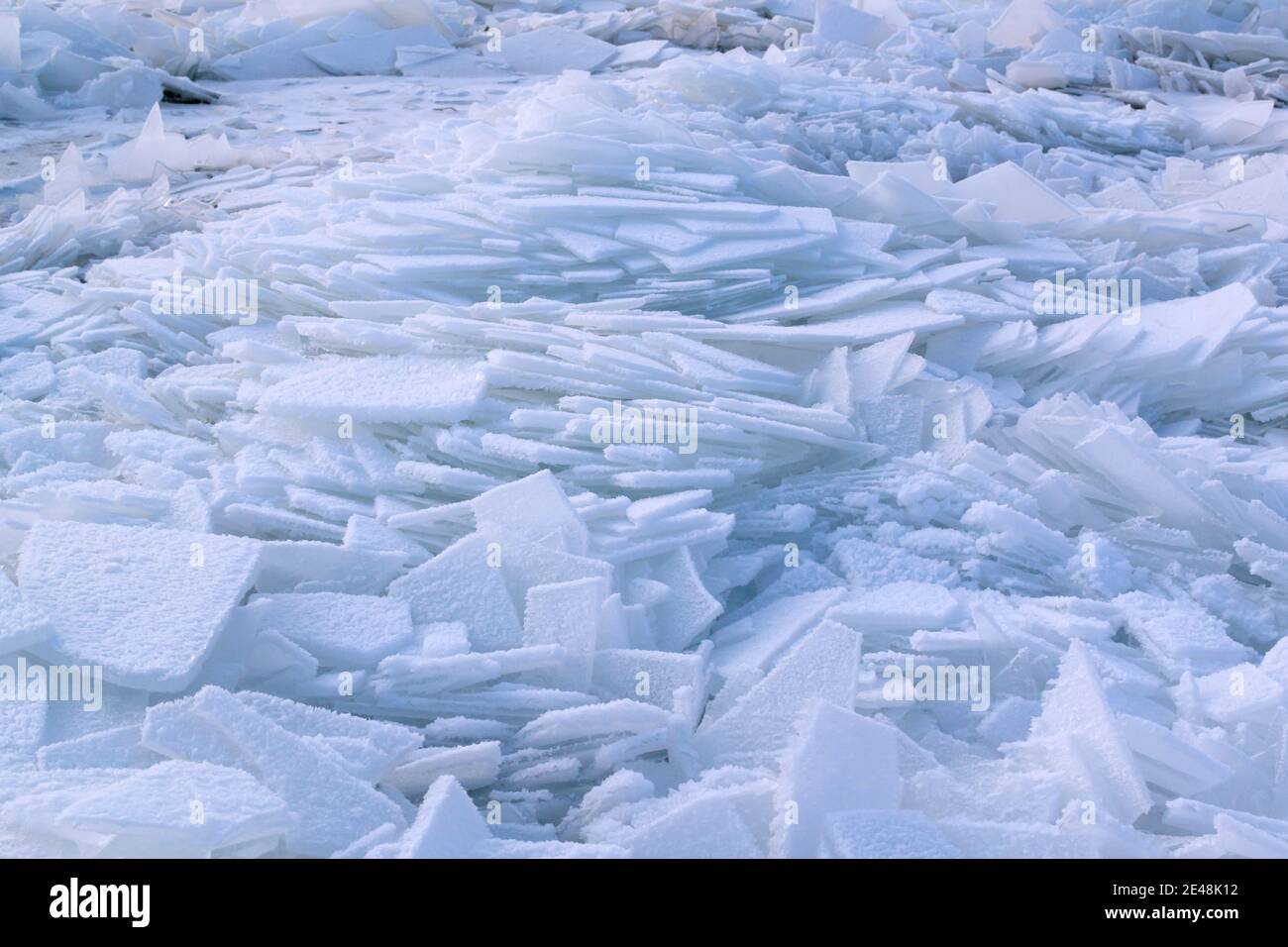 Pieces of blue ice with snow on a frozen reservoir. Winter in Eastern ...