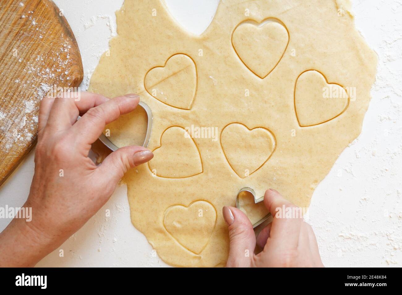 Hands pressing heart shaped cookie cutter into dough Stock Photo - Alamy