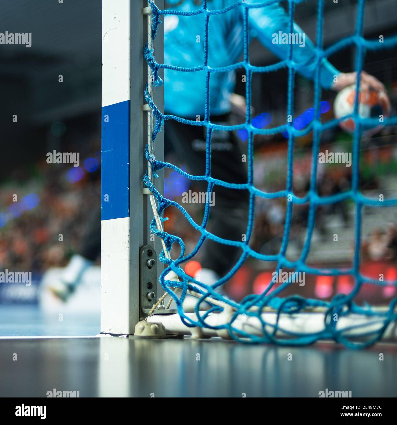 Detail of handball goal post with net and handball match in the ...