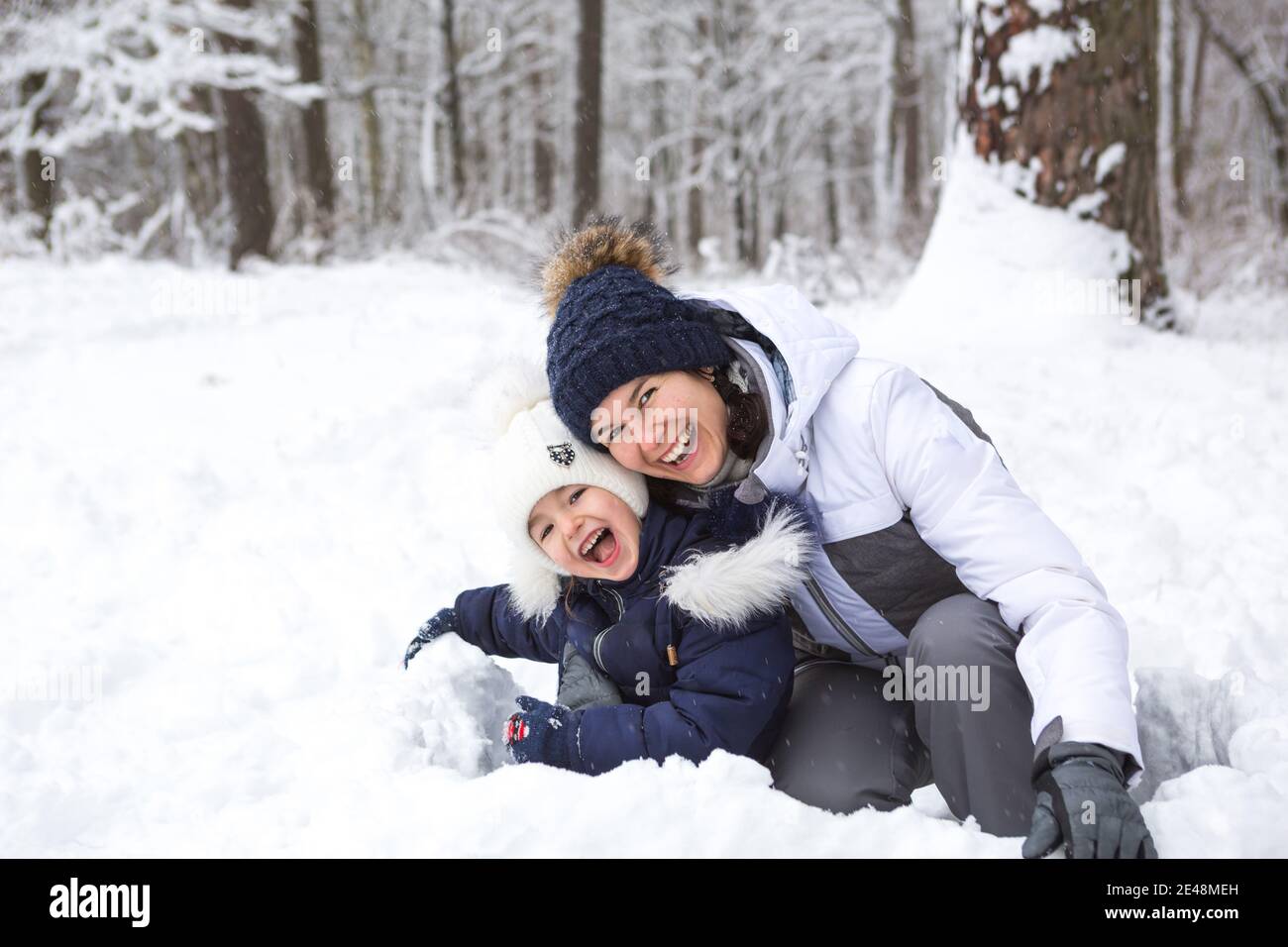 Mom and daughter play snow games, build a fortress, make snowballs ...