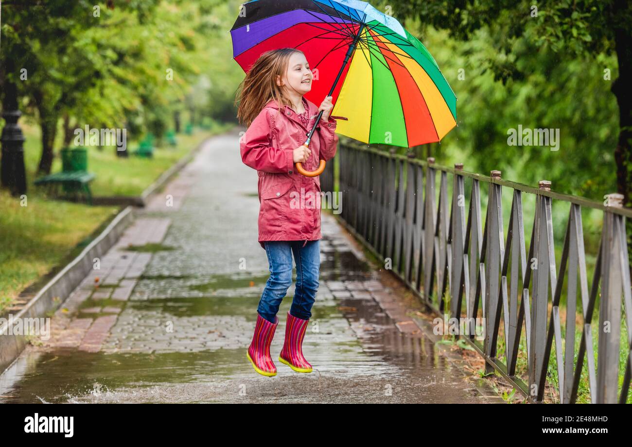 Little girl jumping in puddle Stock Photo - Alamy