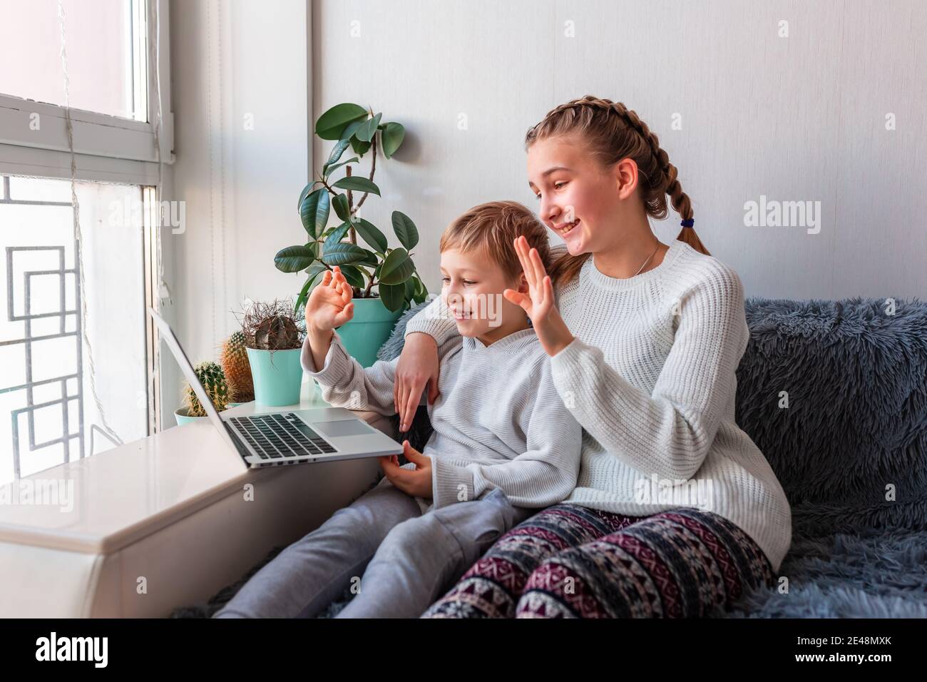 Cute kids having video call with grandparents on laptop during covid ...