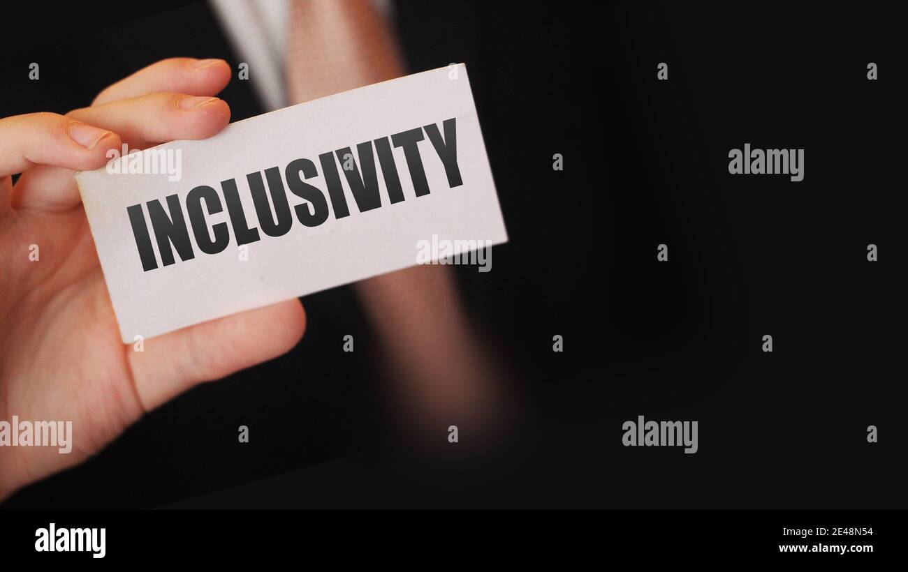 Inclusivity written on a card in businessman's hand. Diversity and ...
