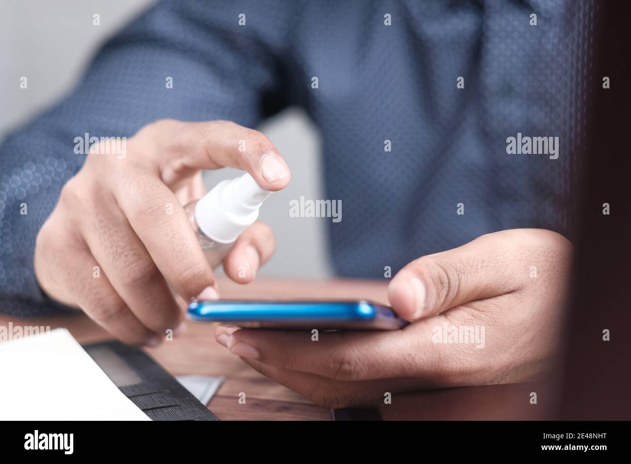 man's hand spray the smart phone display for preventing virus Stock ...