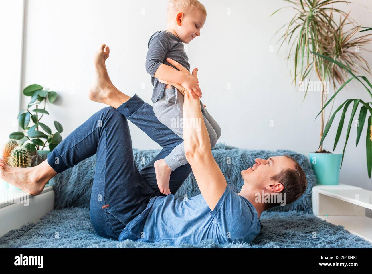 Happy baby boy flying in father's arms looking, loving family dad ...