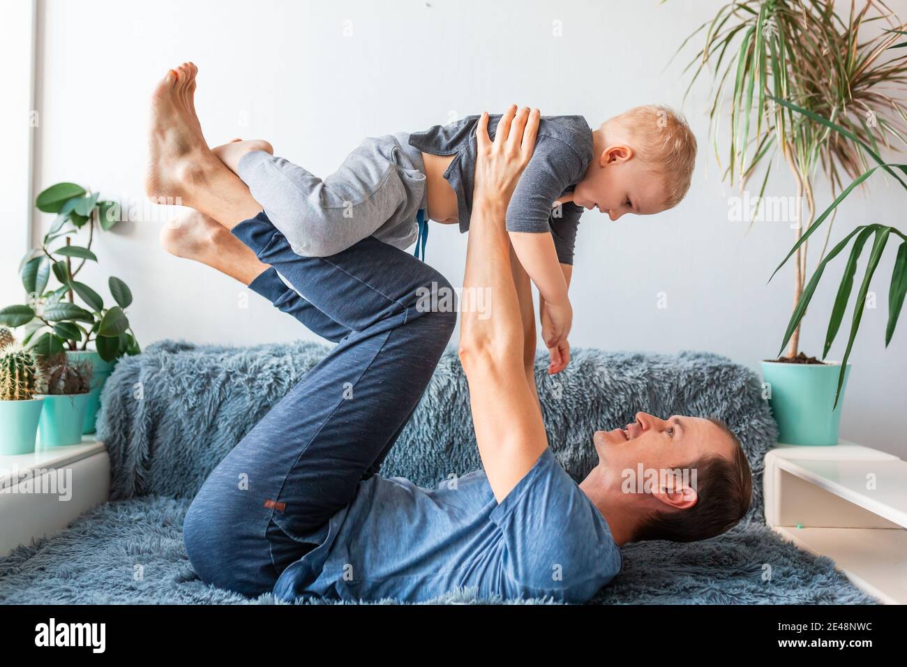 Happy baby boy flying in father's arms looking, loving family dad ...