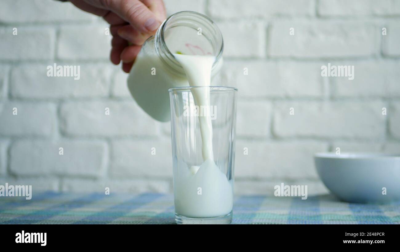One Person Read a Newspaper and Fill a Glass with Fresh Milk for ...