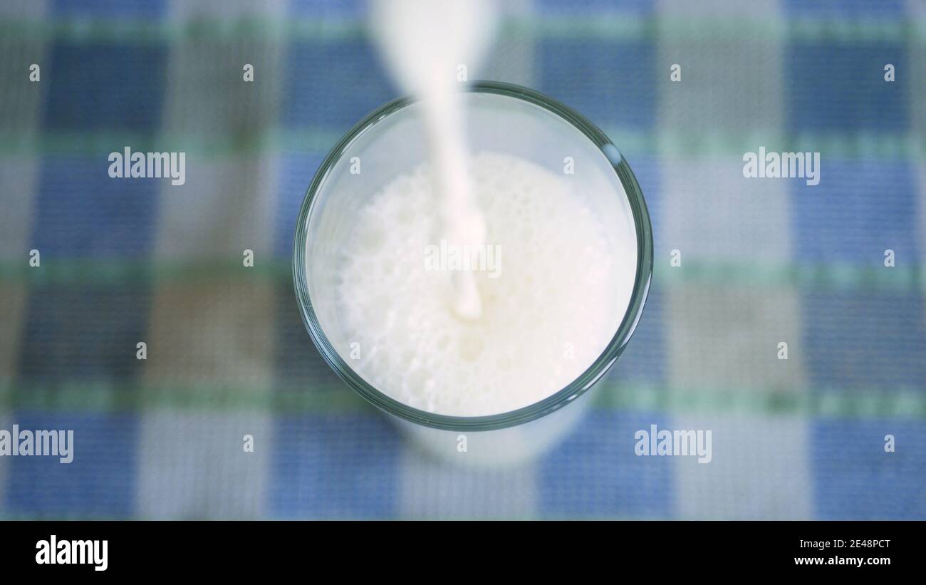 One Person Read a Newspaper and Fill a Glass with Fresh Milk for ...