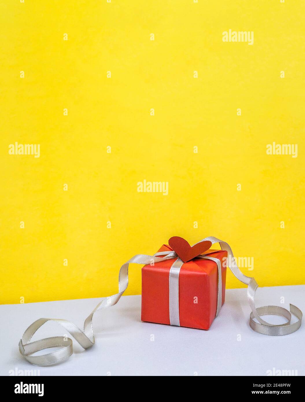 gray-yellow background, birthday gift, gift in red packaging with ...
