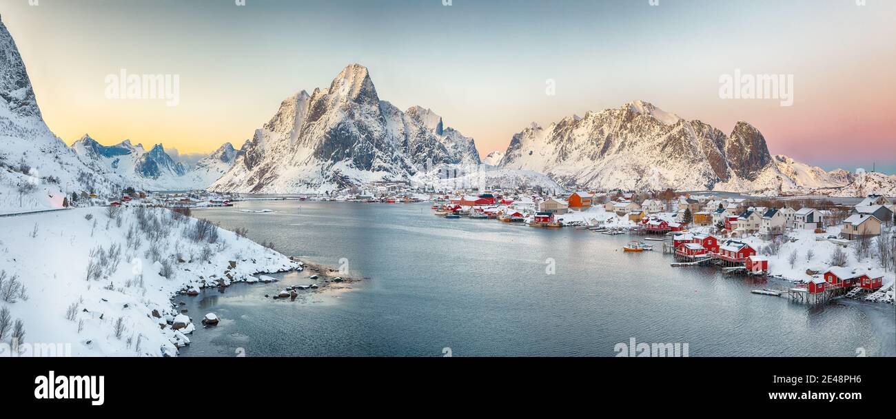 Dramatic evening cityscape of Reine town. Red rorbuers on the shore of ...
