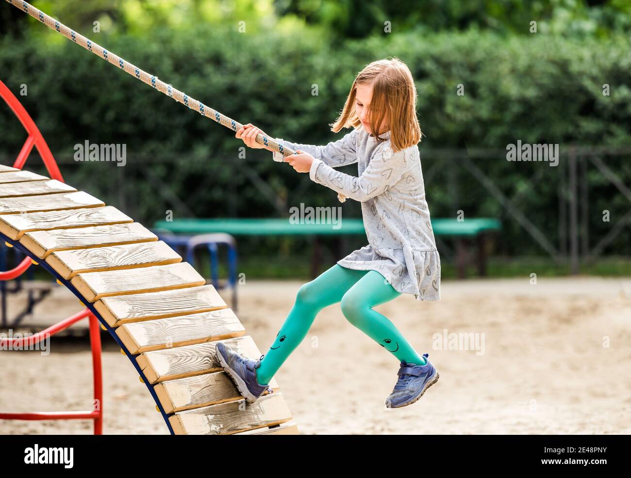 Child climbing with rope on playground Stock Photo - Alamy