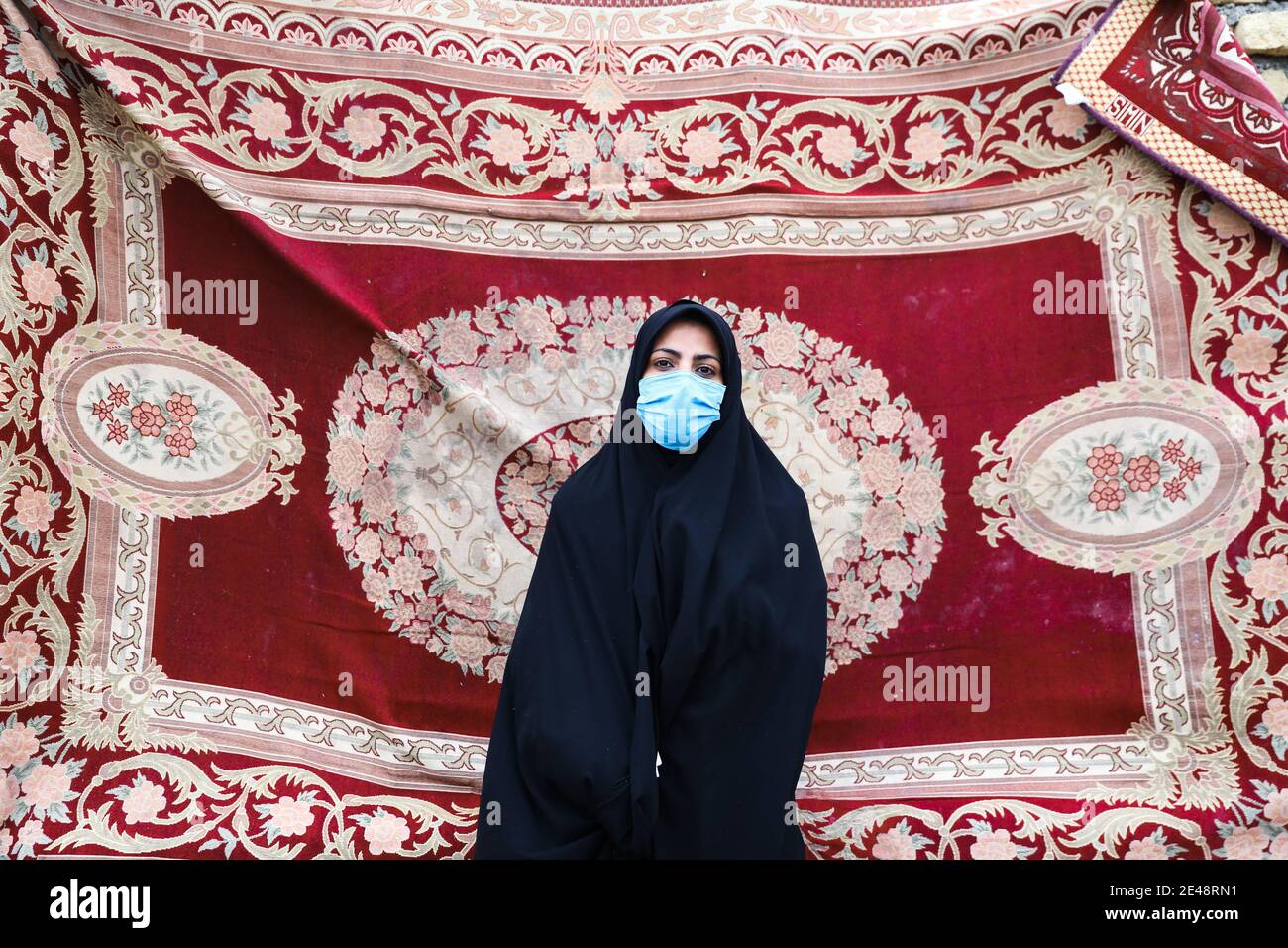An Iranian woman seating in front of Iranian carpet in Radkan, IRan ...