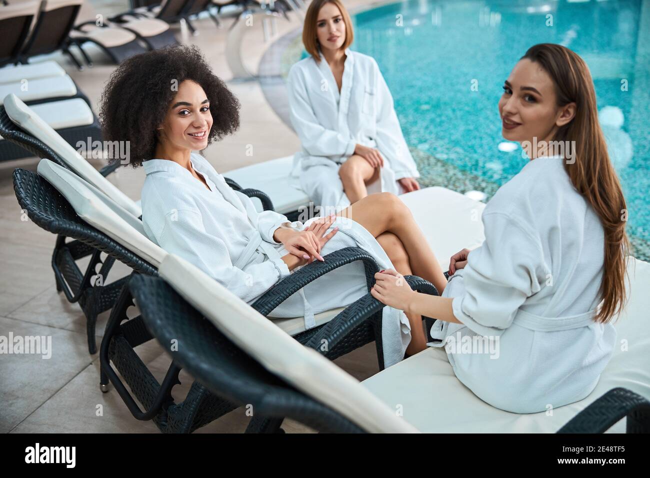 Three girlfriends spending afternoon on the poolside Stock Photo - Alamy
