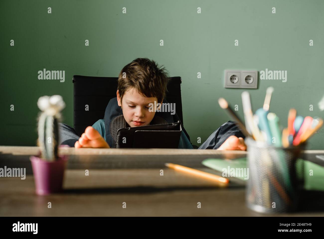 Junior school boy using tablet at home, growing up with technology ...