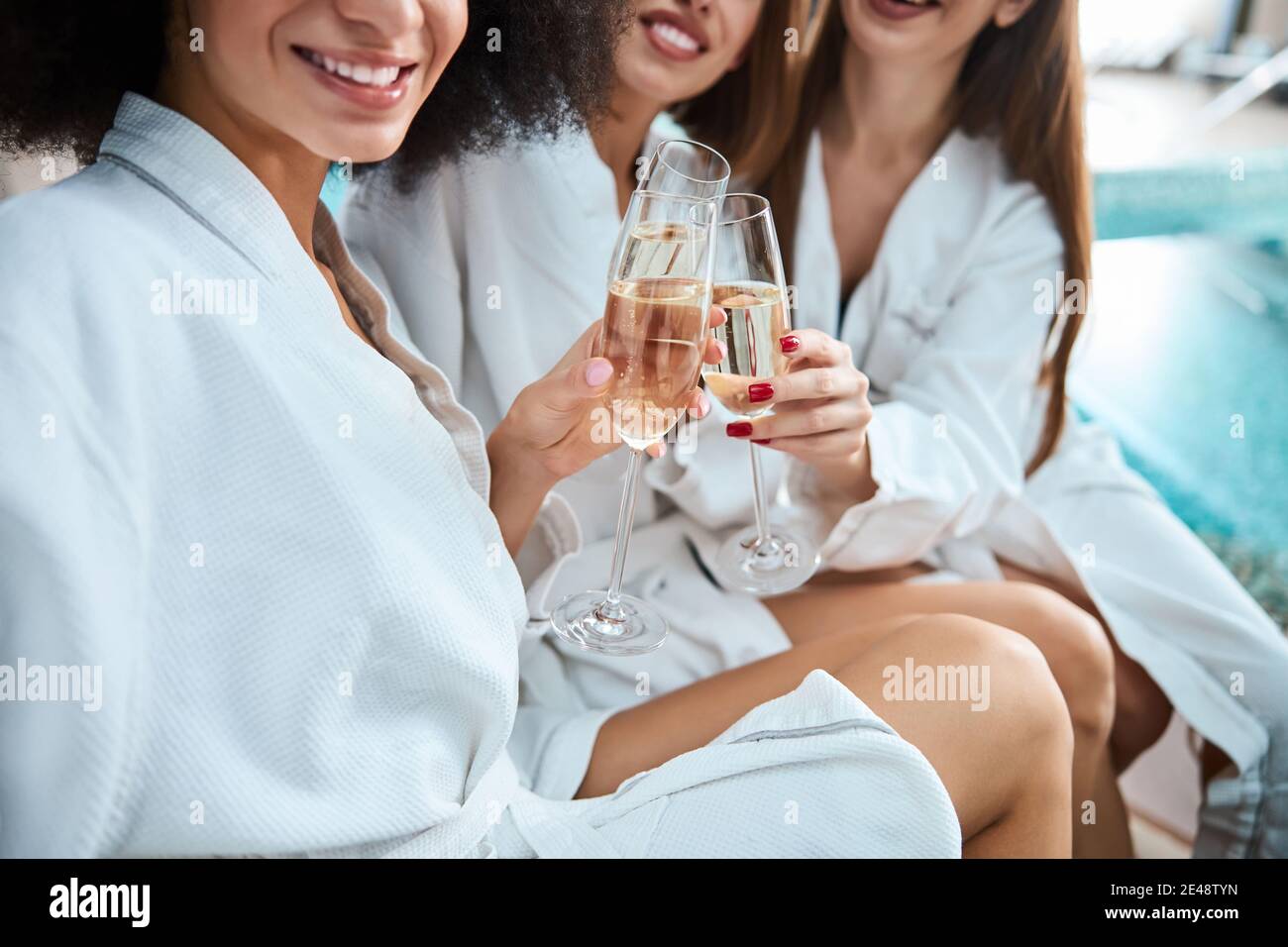 Cheerful ladies hanging out together abd drinking on poolside Stock ...