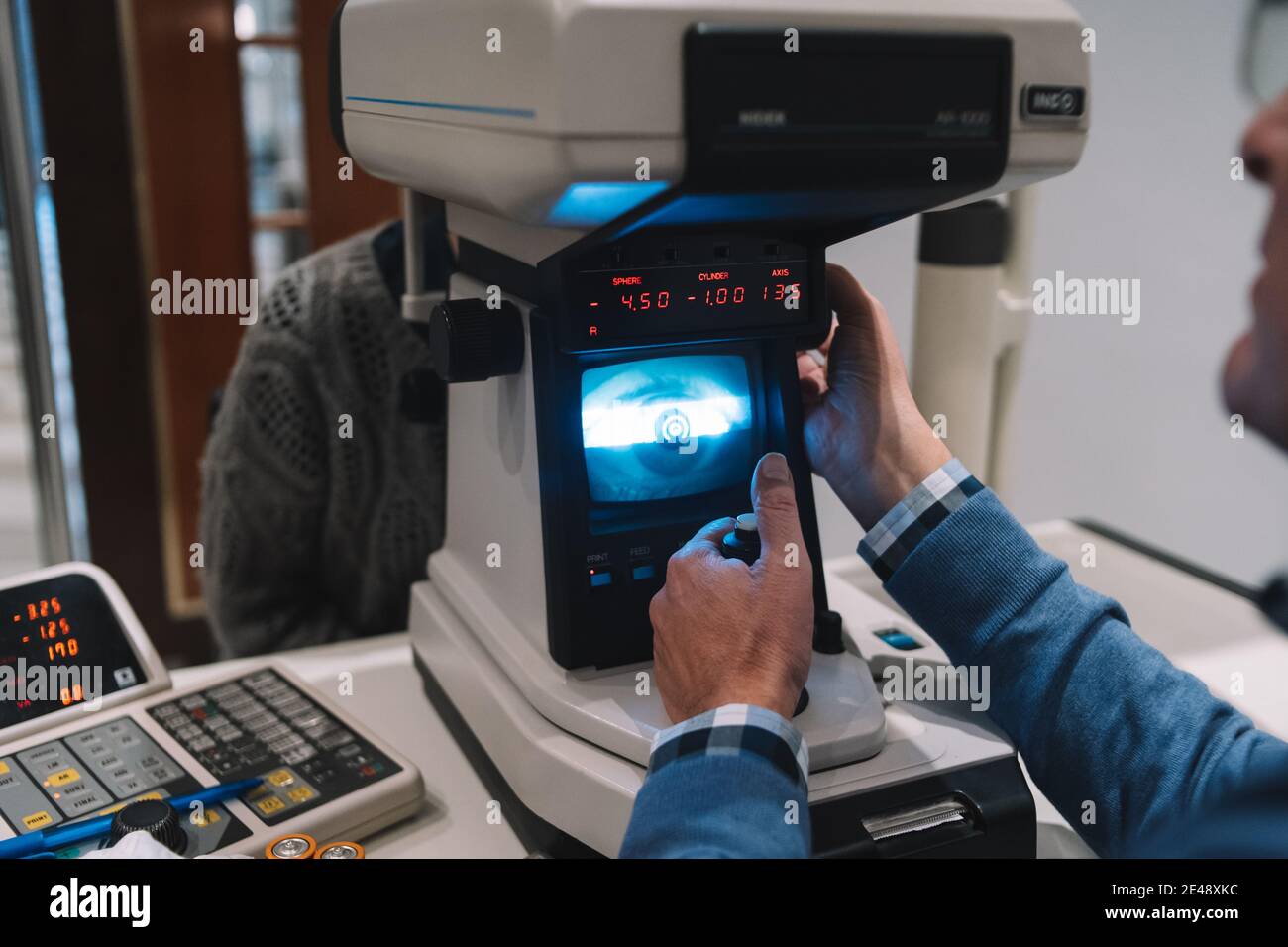 Close-up of an optic specialist views eyesight to a girl patient in an ...