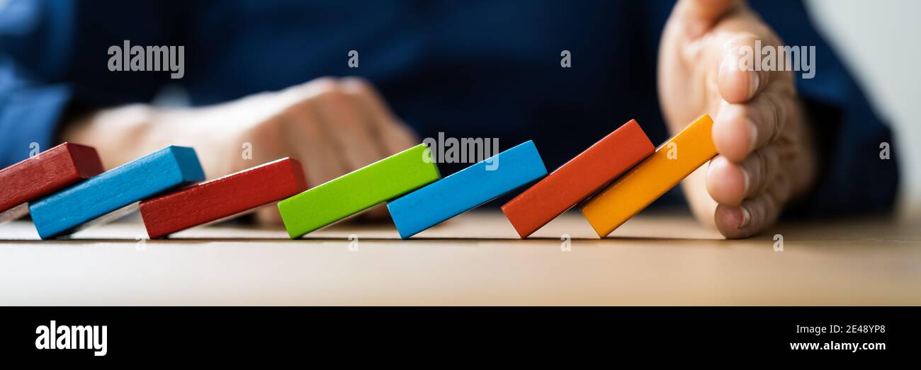 Domino Fall Risk Prevention. Hand Stopping One Stock Photo - Alamy