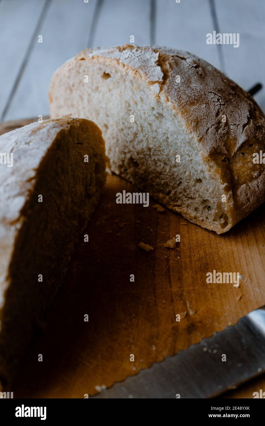 Delicious homemade no-knead bread cut in half over a wooden board Stock ...