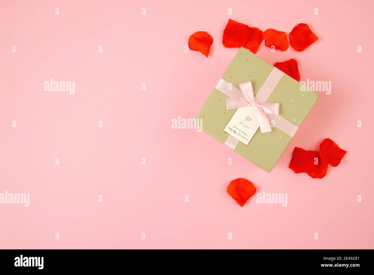 Pink background with present and rose leaves around Stock Photo - Alamy