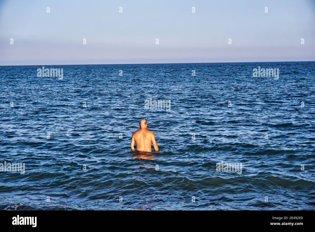 Back view of a man swimming in the blue oc Stock Photo - Alamy
