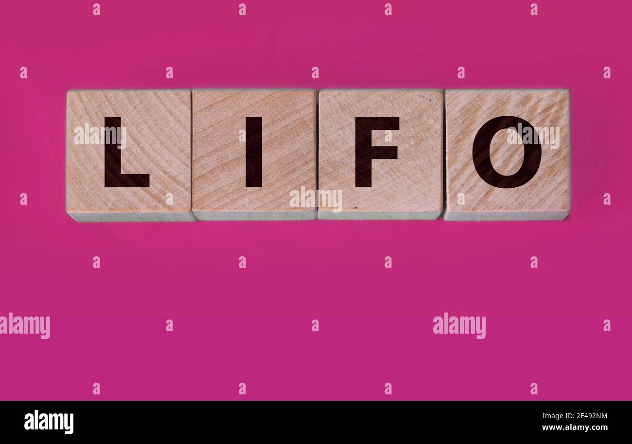 LIFO Last in, first out abbreviationon wooden cubes on pink. Accounting ...