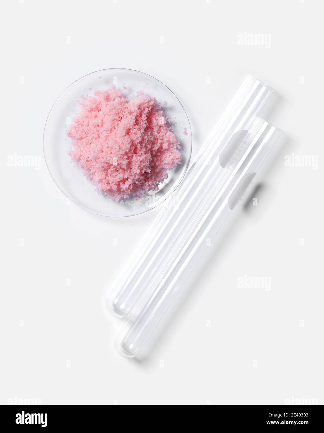 Pink flake chemicals in Chemical Watch Glass and test tube on white ...