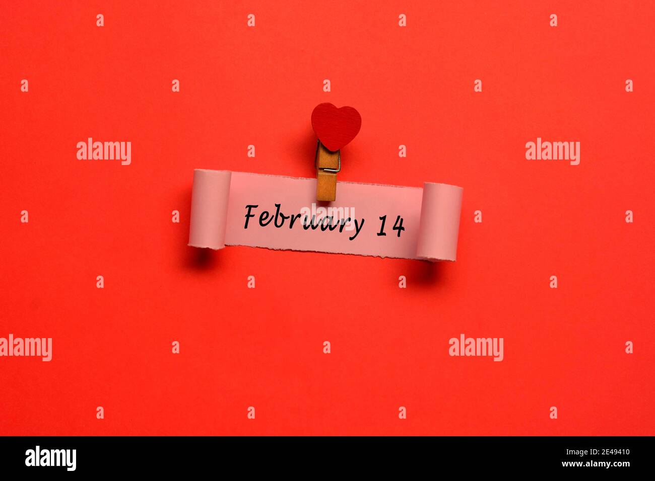 February 14 label on torn paper with red paper background. Valentine's ...