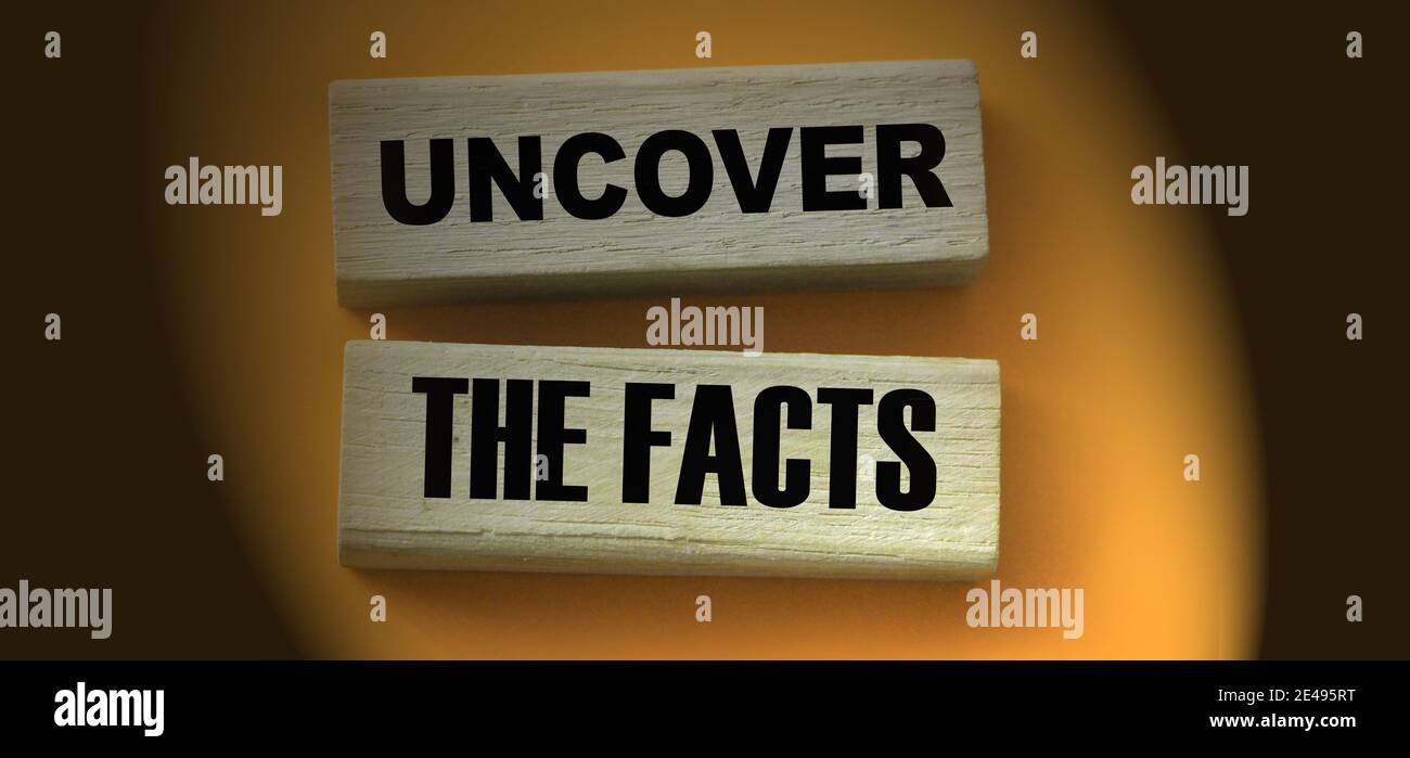 Uncover the facts word on wooden blocks on red background. Fake or real ...
