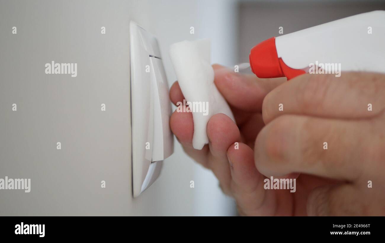 Man Cleaning and Disinfecting Light Switch from the Office Room Using ...