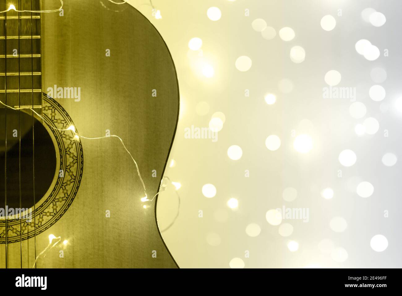 acoustic guitar wrapped in a luminous garland with bokeh. Christmas ...