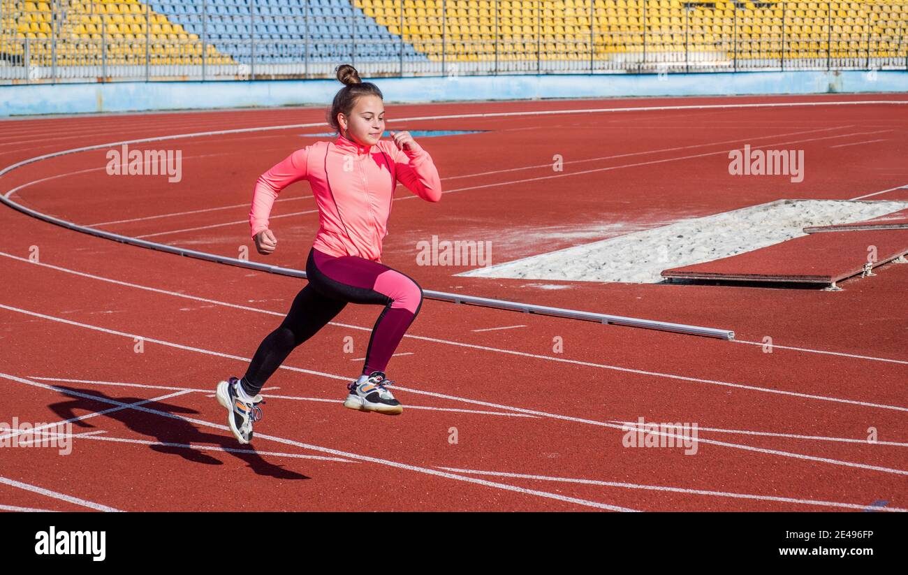 teen girl running on outdoor stadium racing track, marathon Stock Photo ...