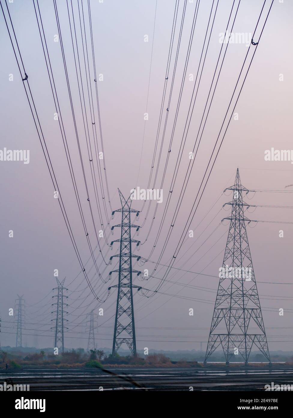 High-voltage power lines at sunset. Electricity distribution station ...