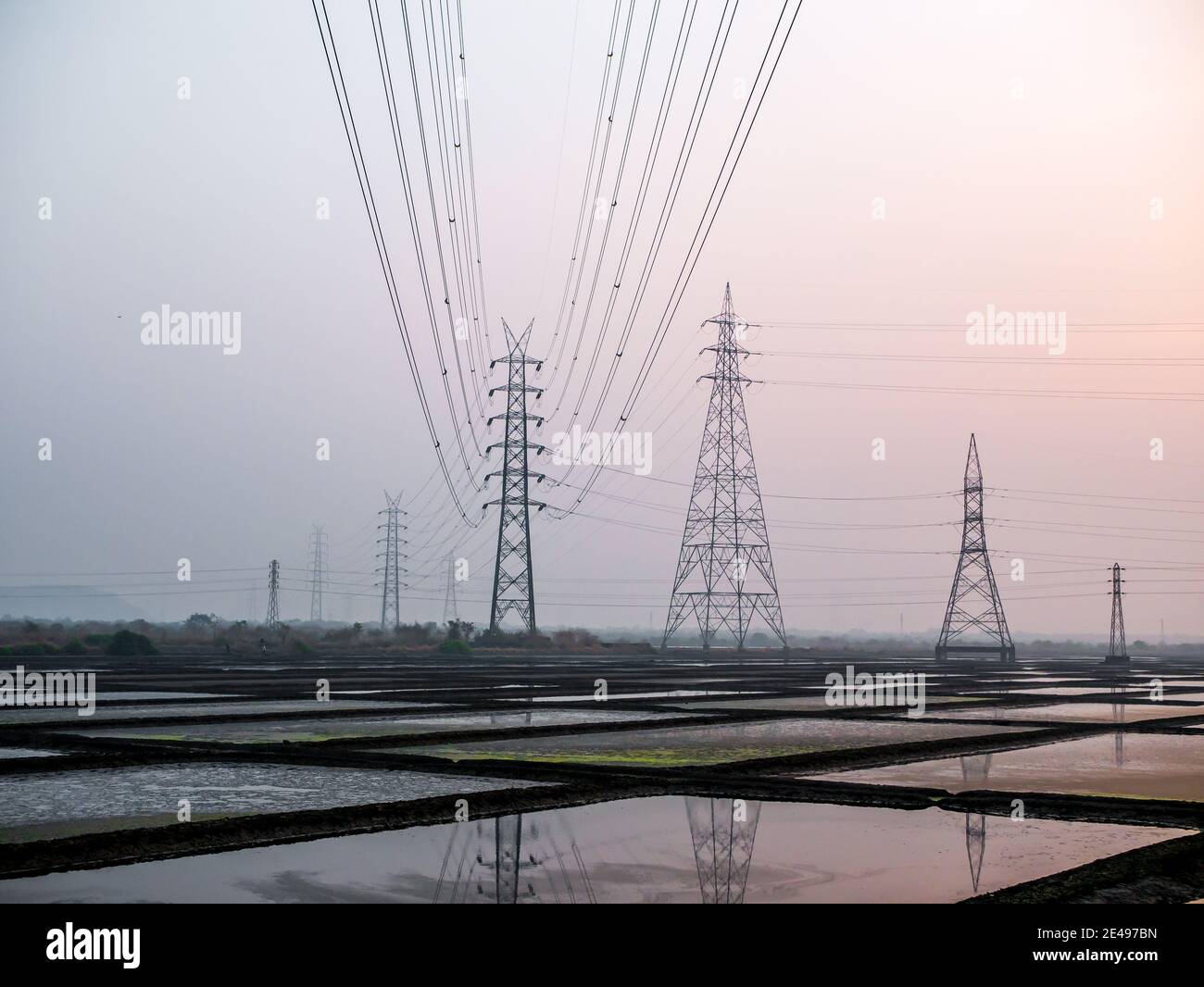 Reflection of High voltage power lines in Sea salt farm and barn at ...