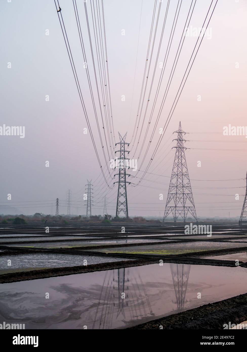 Reflection of High voltage power lines in Sea salt farm and barn at ...