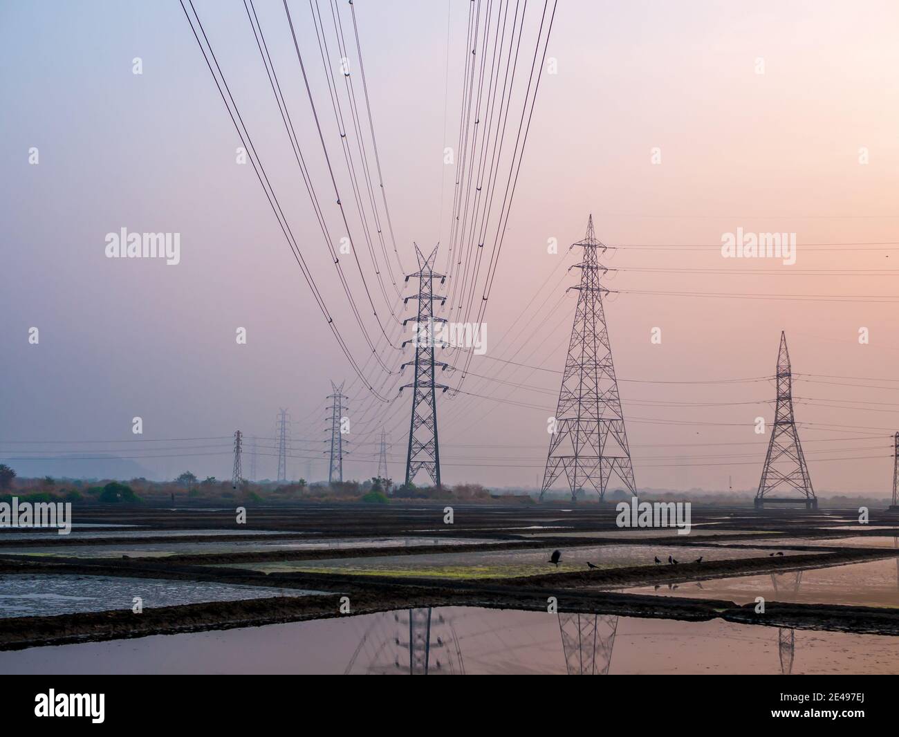 Reflection of High voltage power lines in Sea salt farm and barn at ...