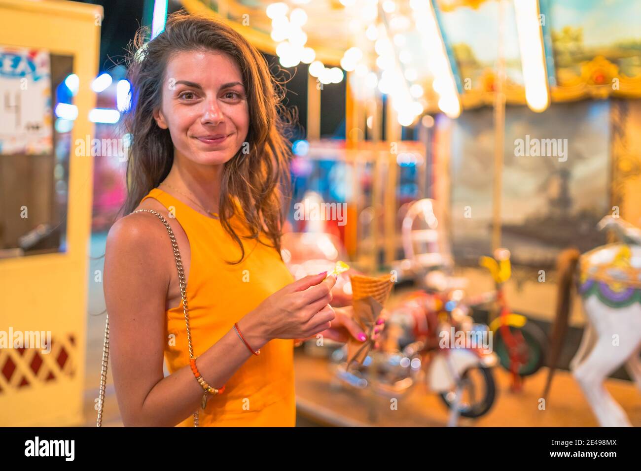Portrait of young happy smiling woman holding waffle cone and posing ...