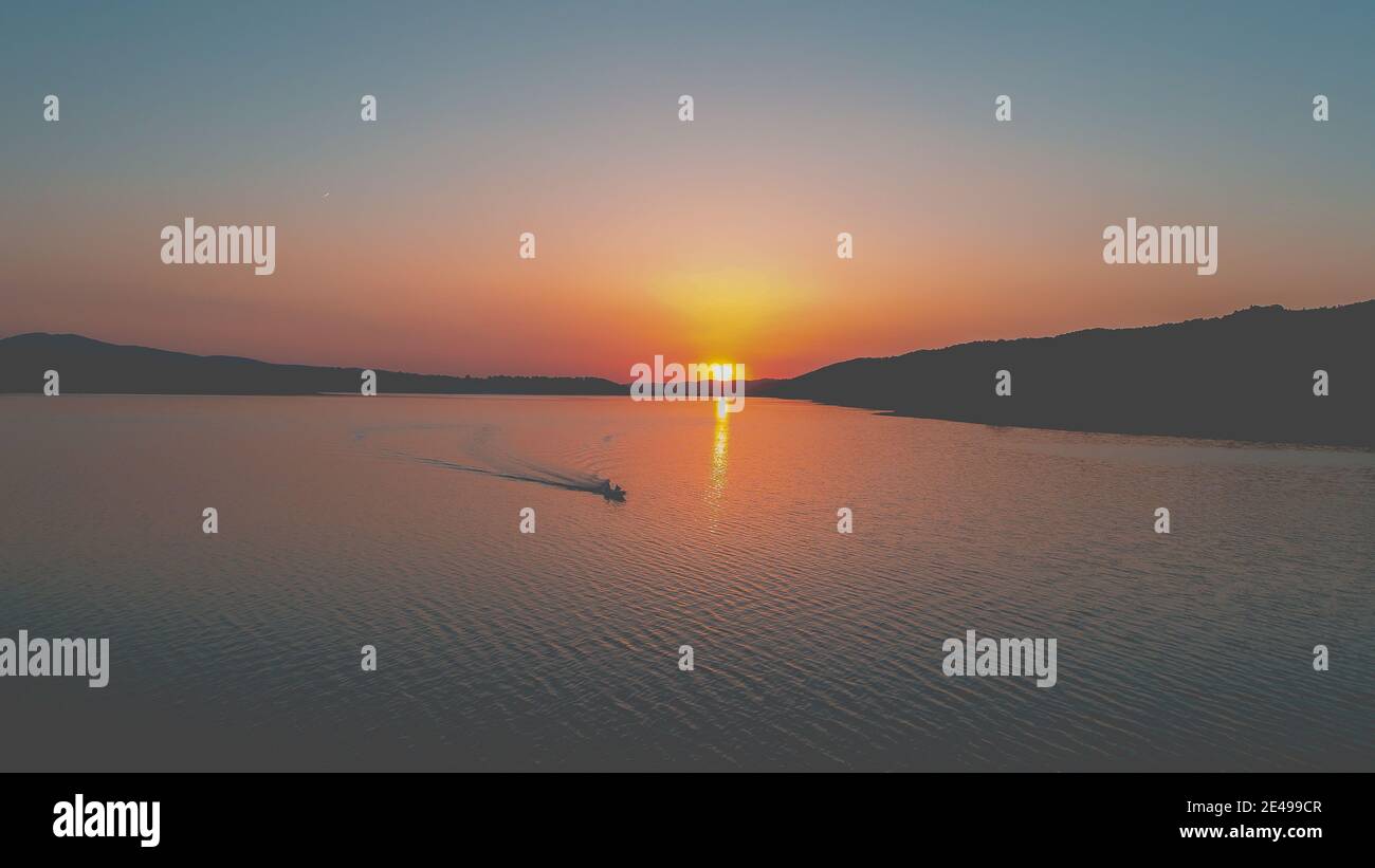 Boat and sunset over dam Stock Photo - Alamy