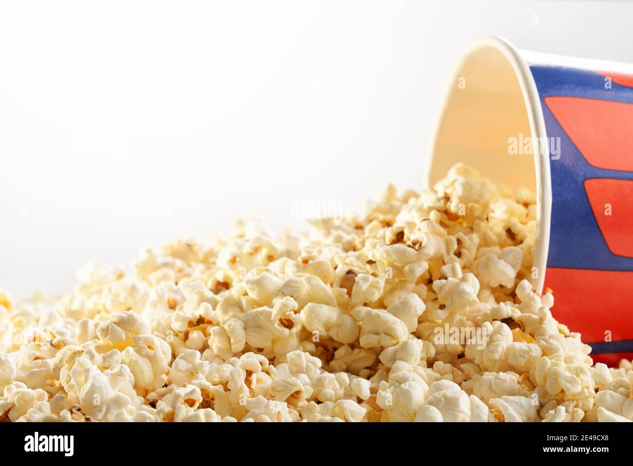 Popcorn spilled of paper box on white background. Concept of cinema ...