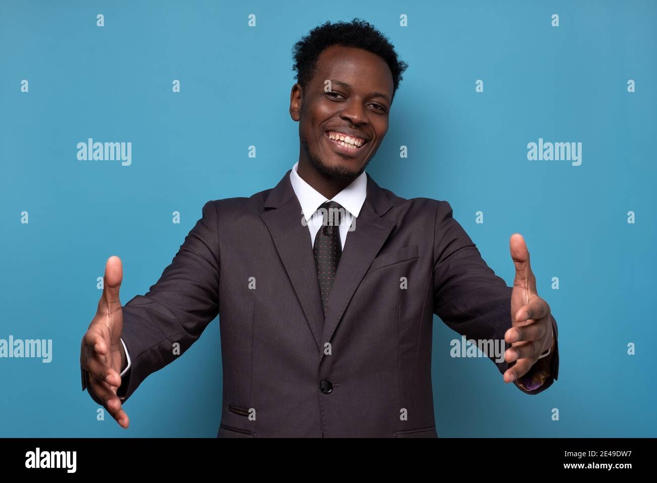 Young handsome african man smiling cheerful with open arms as friendly ...