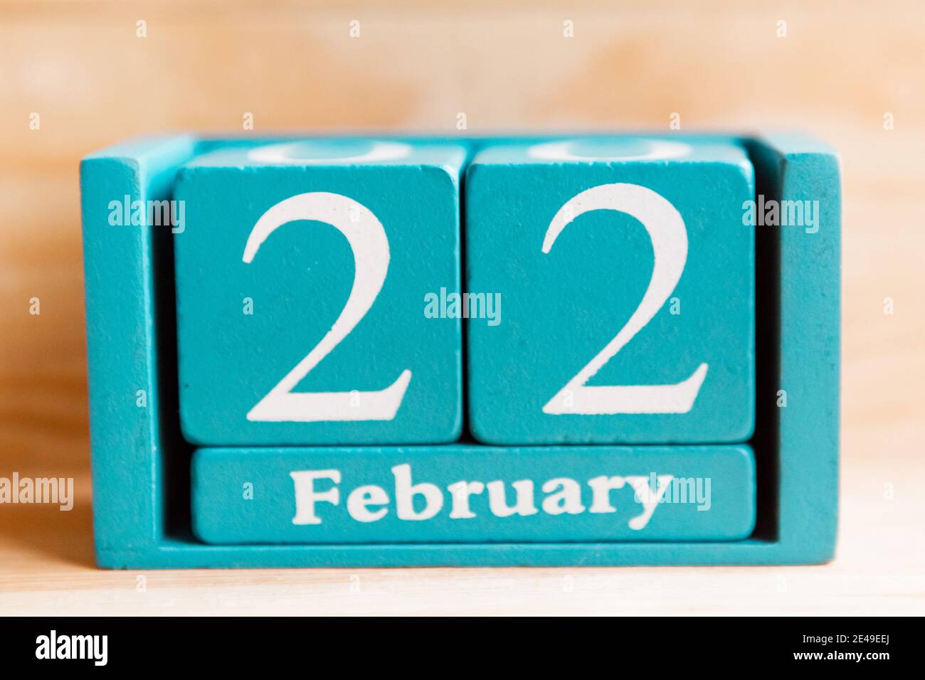 February 22. Blue cube calendar with month and date on wooden ...