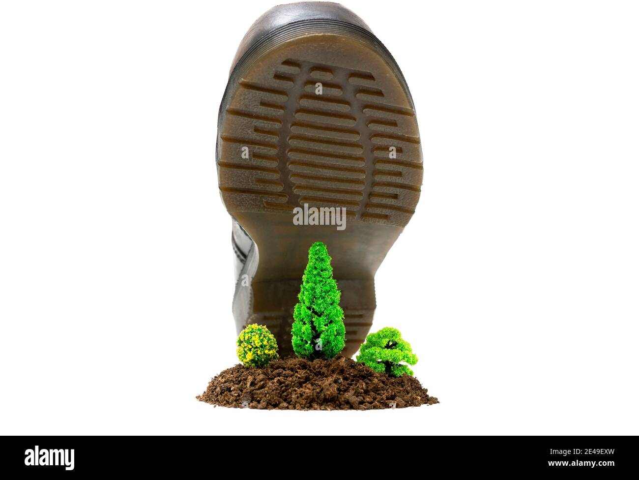 Big work boot stepping on a small miniature forest made of soil and toy ...