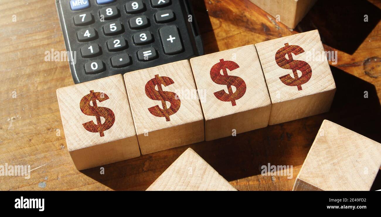 Wooden blocks with dollar sign and calculator. Financial plan business ...
